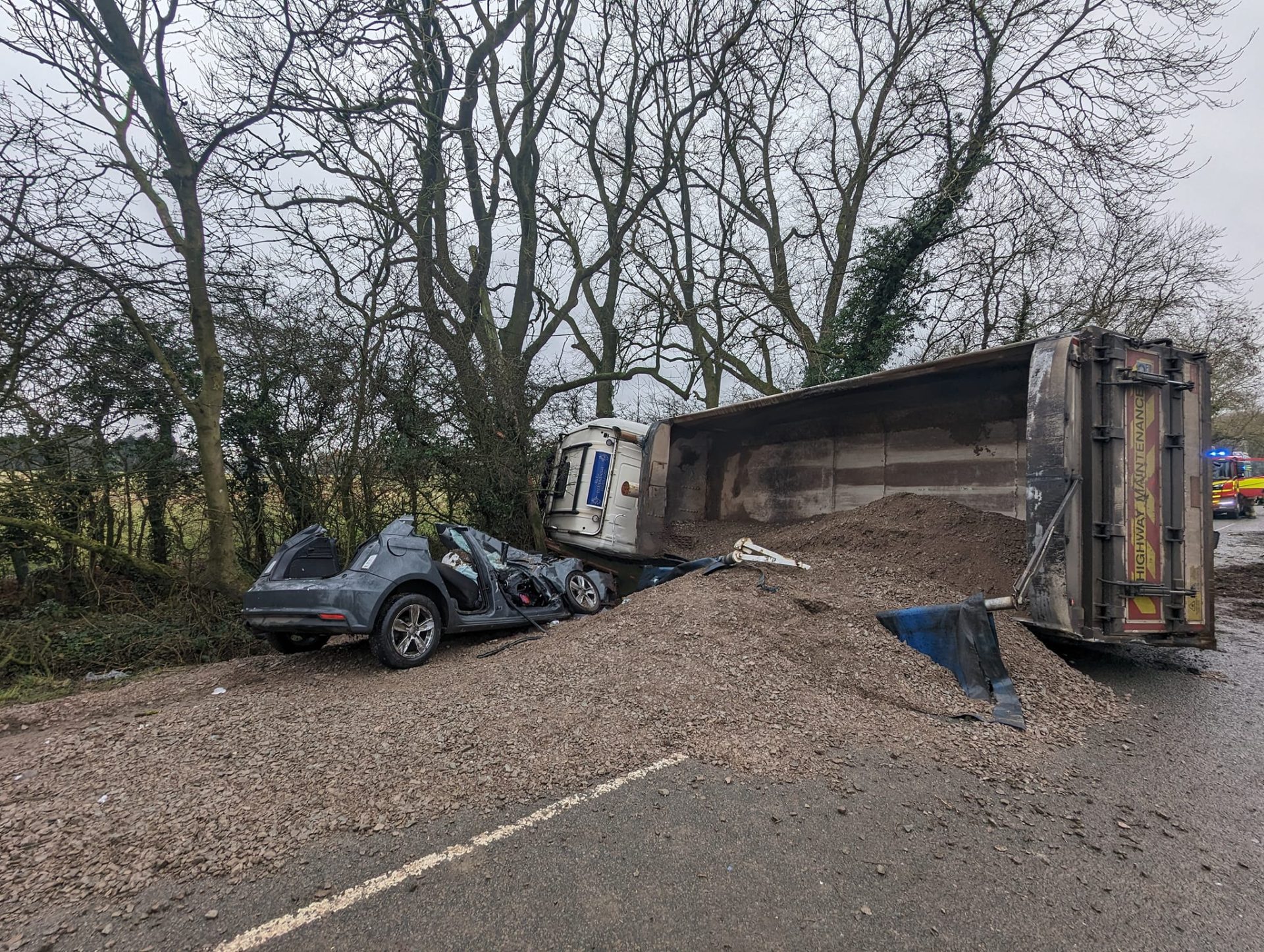 Fire service warning after tipper lorry overturns on wet roads dumping ...